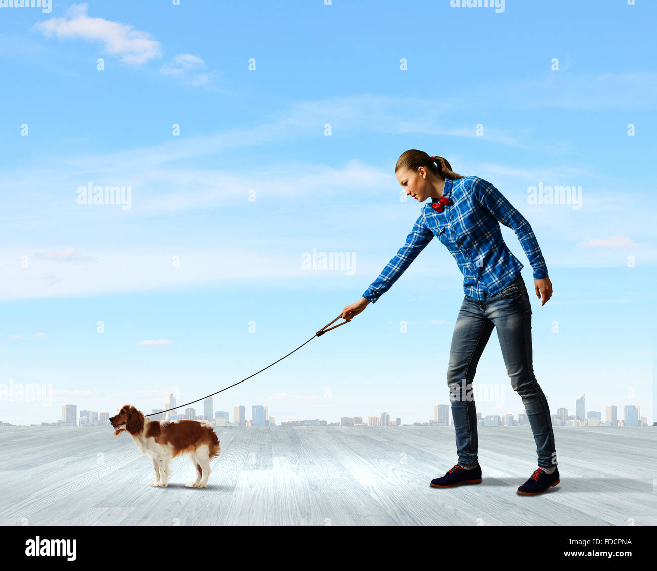Young woman in casual holding dog on lead Stock Photo - Alamy