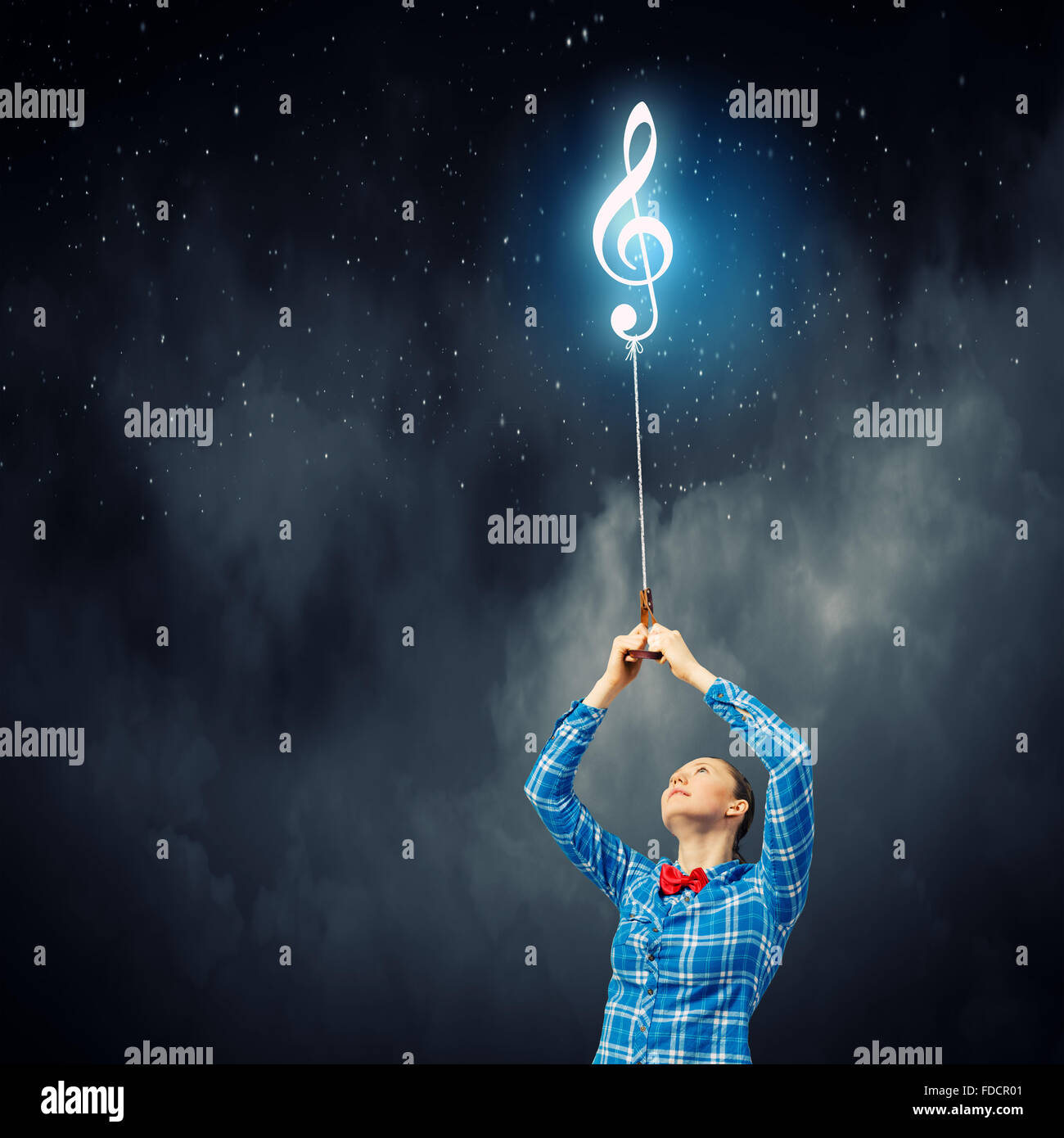Young woman holding music sign on rope Stock Photo - Alamy