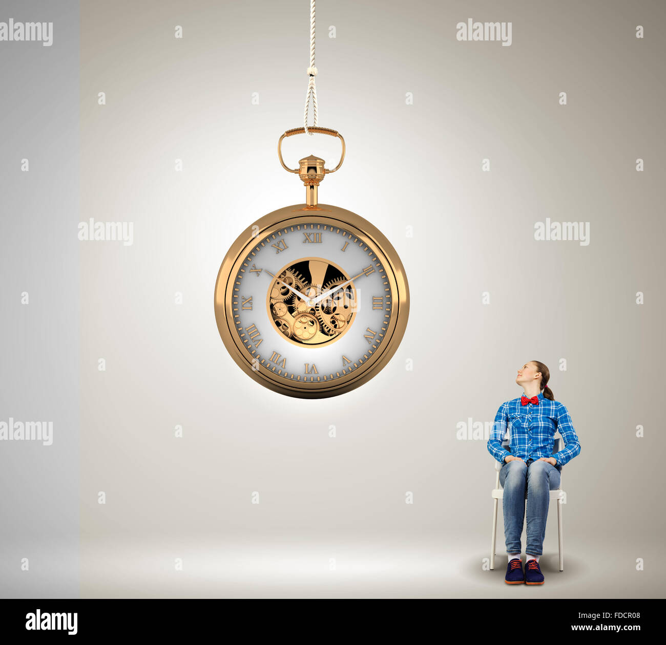 Young woman in casual looking at pocket clock Stock Photo - Alamy
