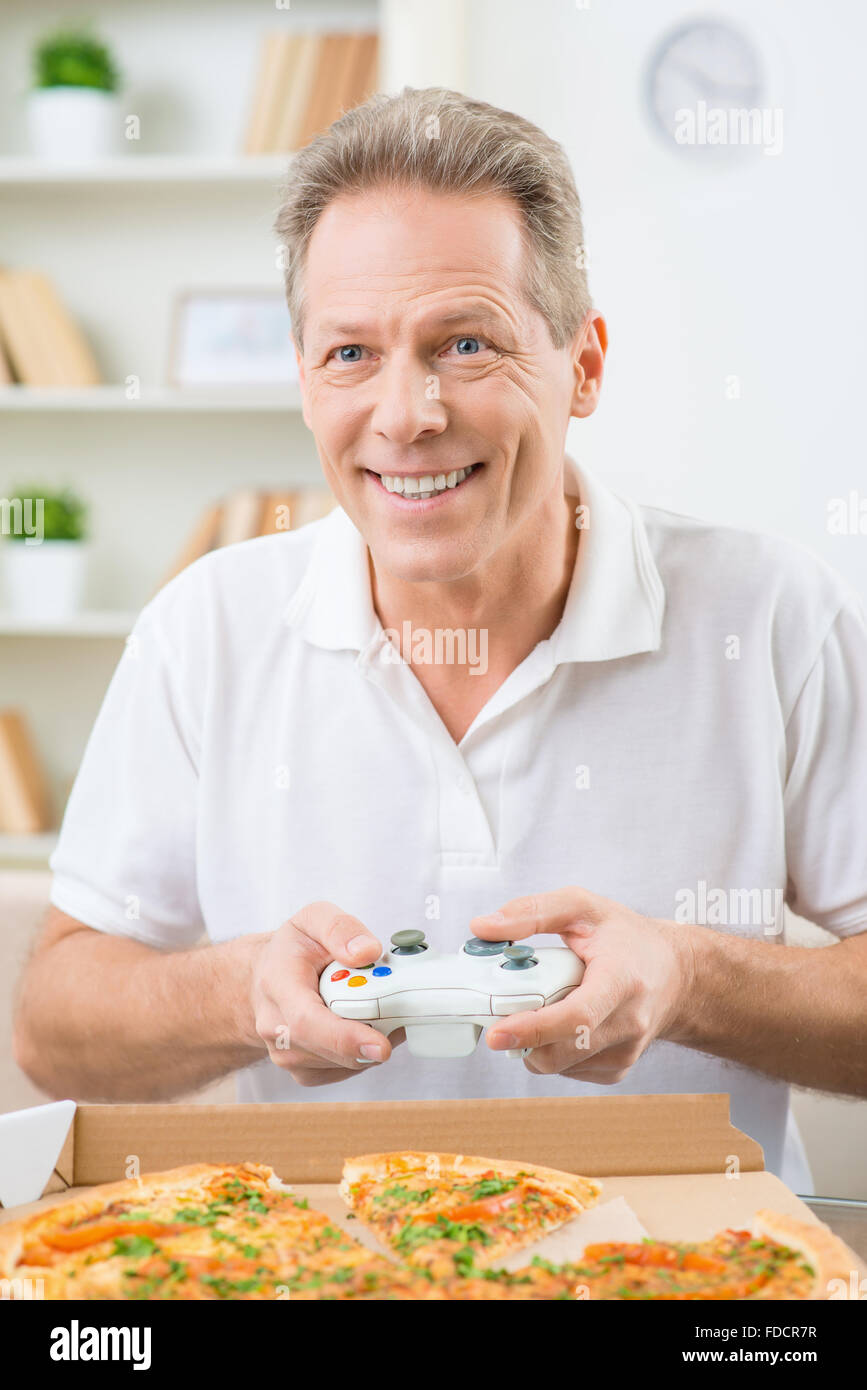 Positive man playing video game Stock Photo - Alamy