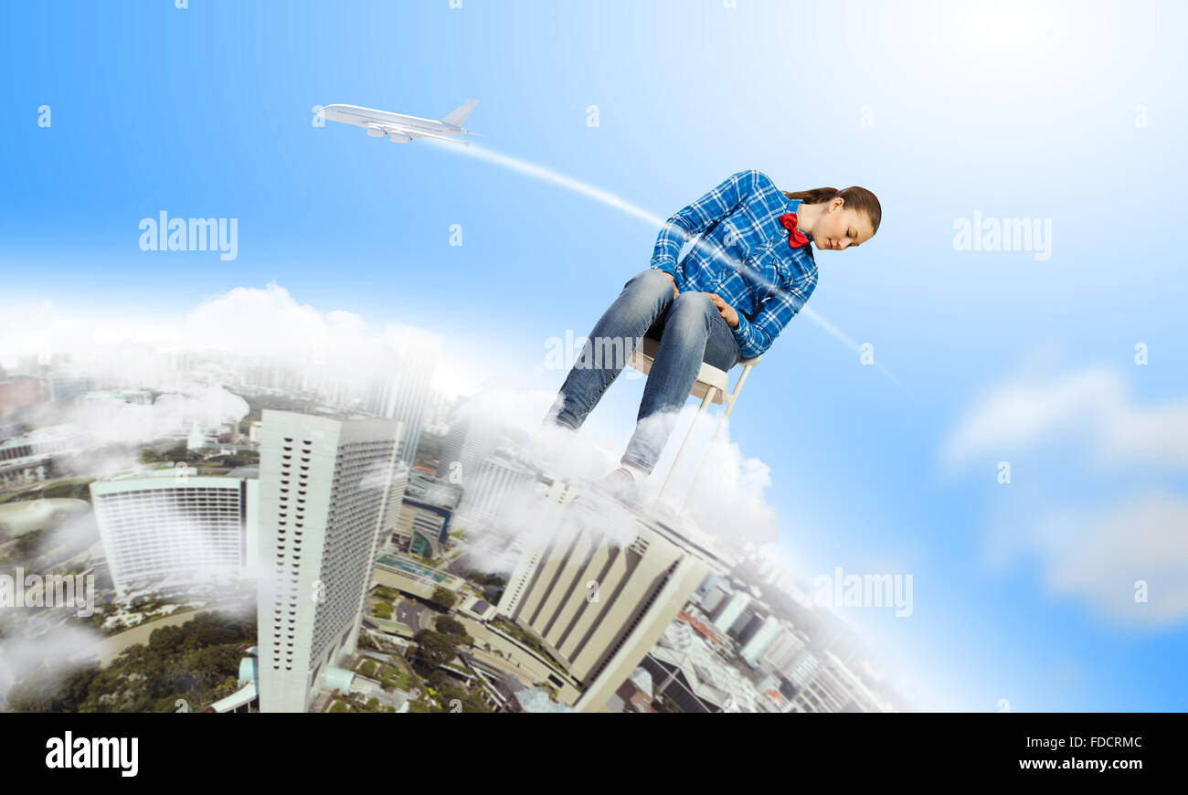 Young giant woman sitting on chair above modern city Stock Photo - Alamy