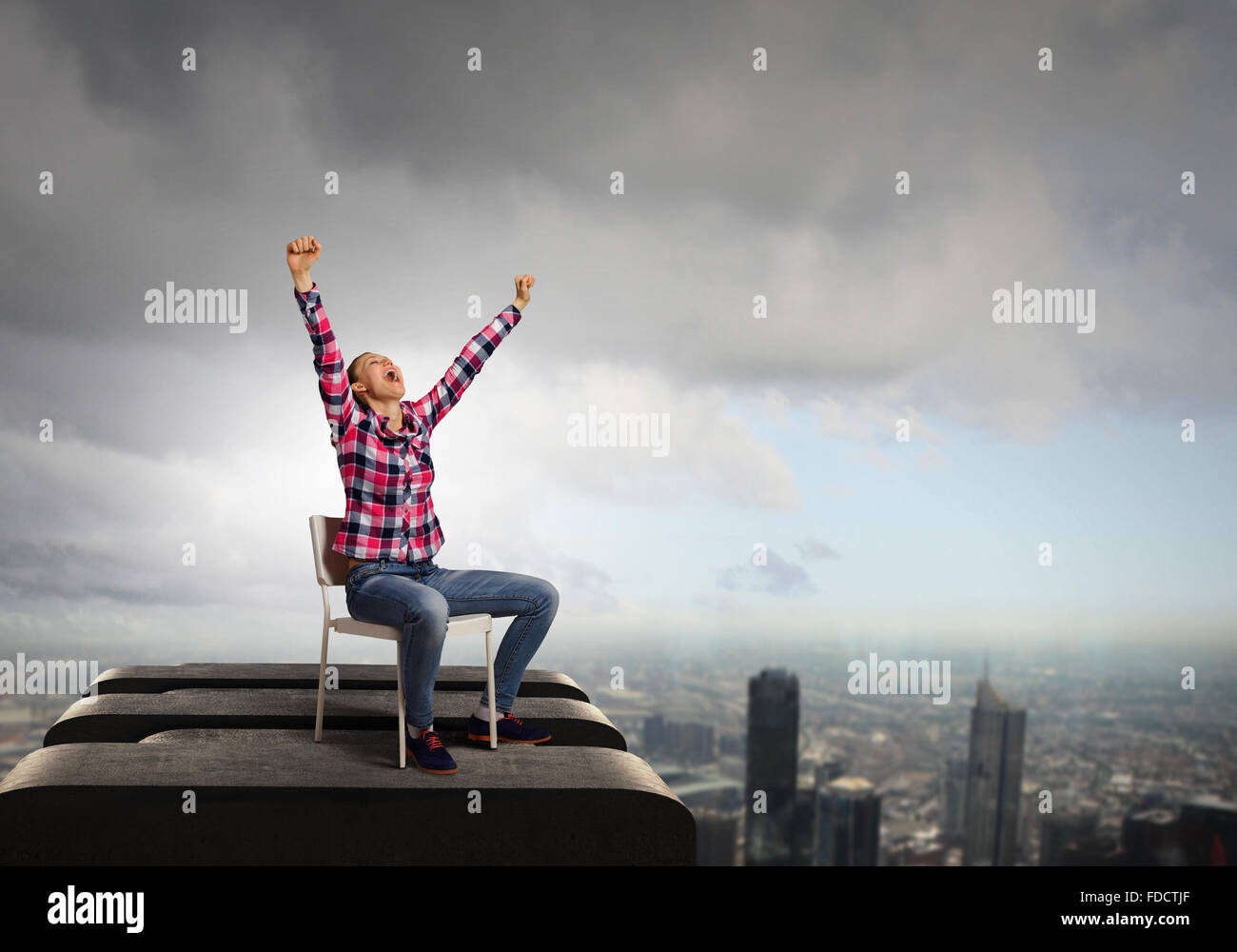 Young woman in casual with arms up celebrating success Stock Photo - Alamy