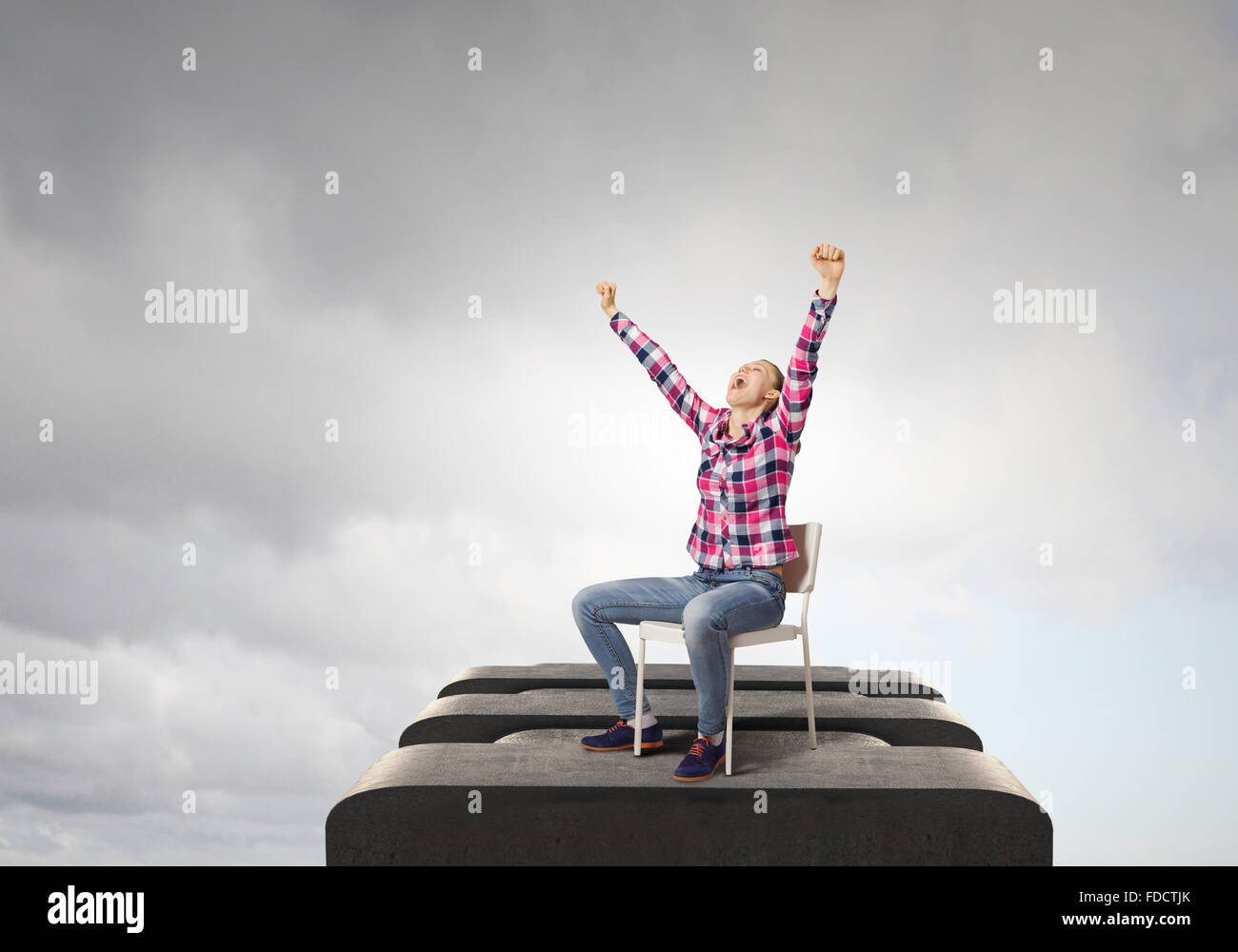 Young woman in casual with arms up celebrating success Stock Photo - Alamy