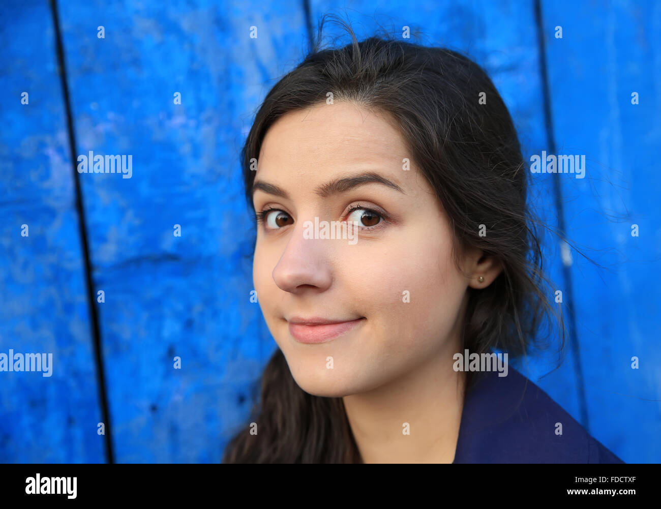 Beautiful young woman on background of blue wall Stock Photo - Alamy
