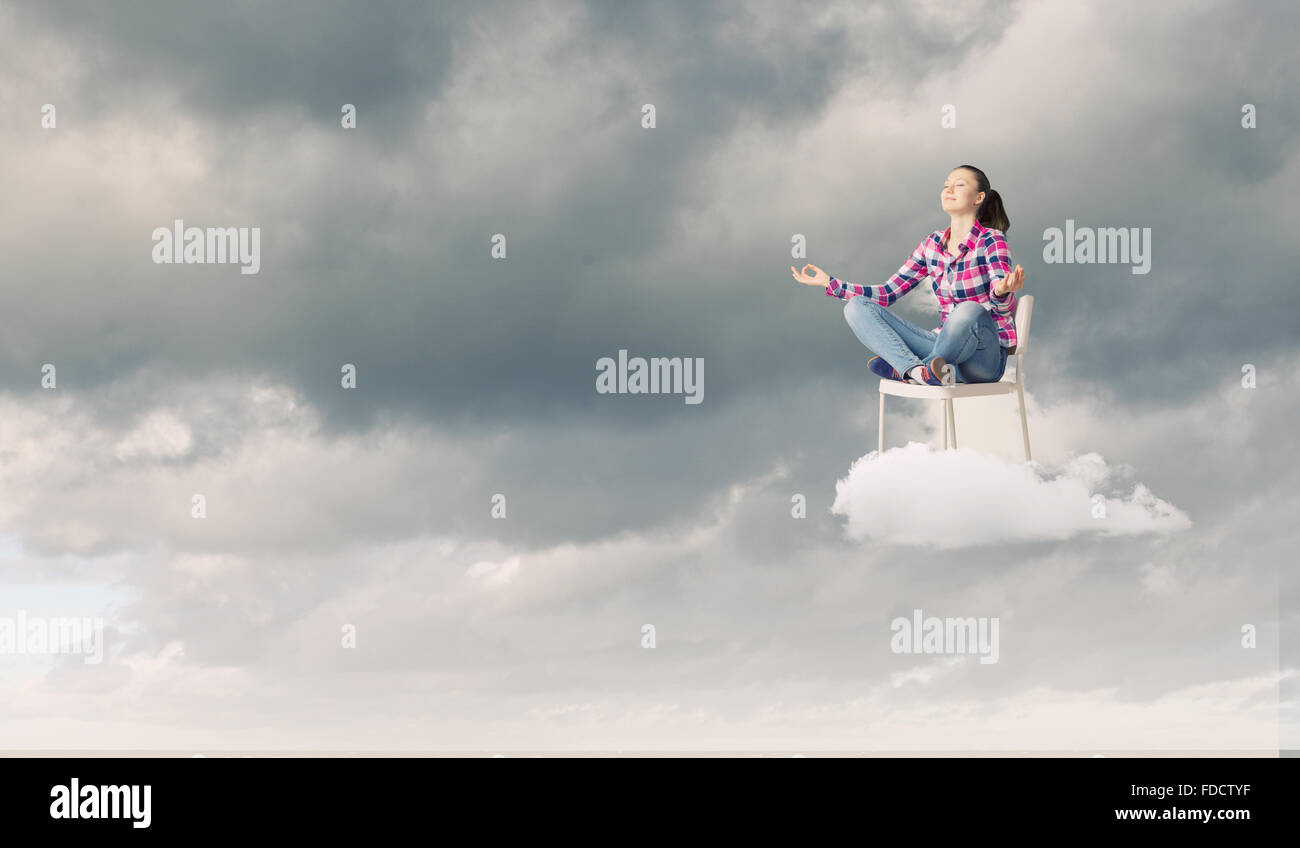 Young woman sitting on chair and meditating Stock Photo - Alamy