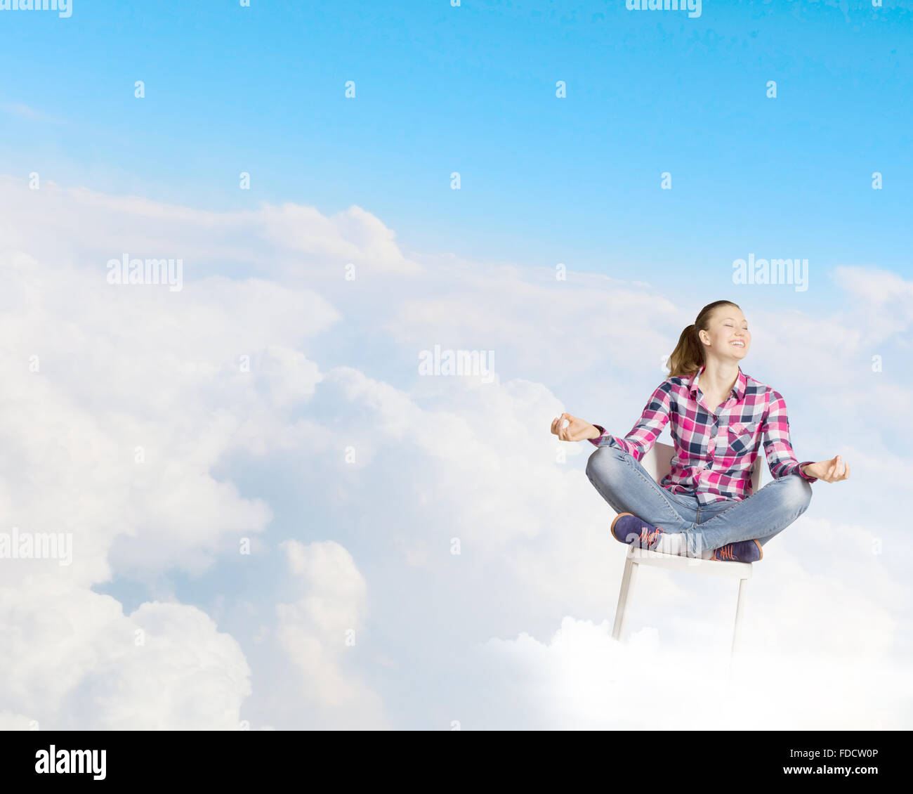 Young woman sitting on chair and meditating Stock Photo - Alamy