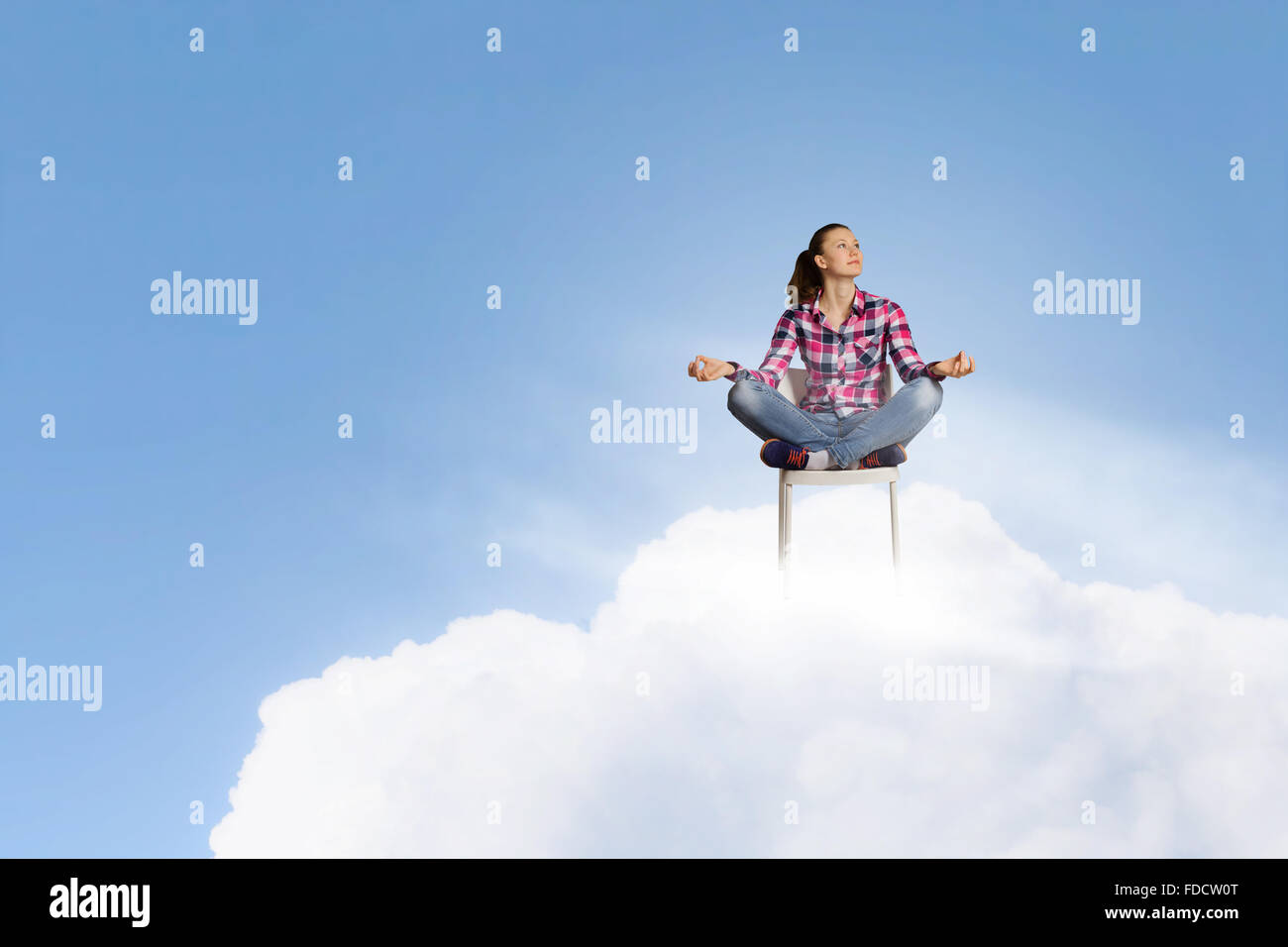 Young woman sitting on chair and meditating Stock Photo - Alamy