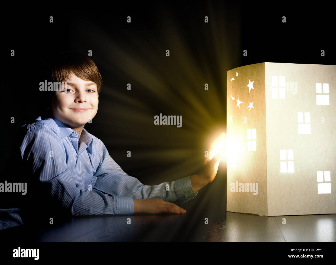 Cute little boy in dark room dreaming about home and family Stock Photo ...