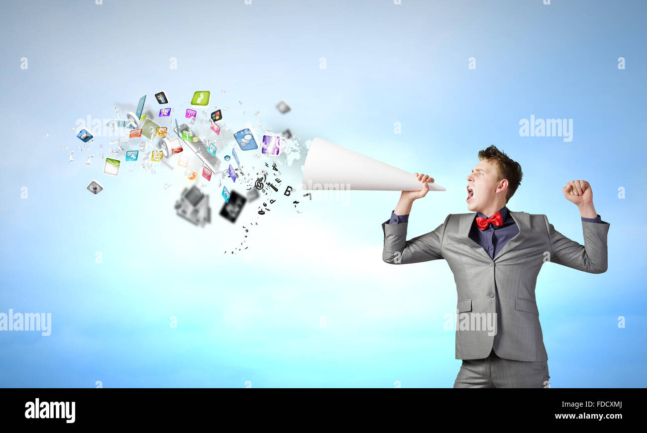 Young businessman screaming emotionally in paper trumpet Stock Photo ...