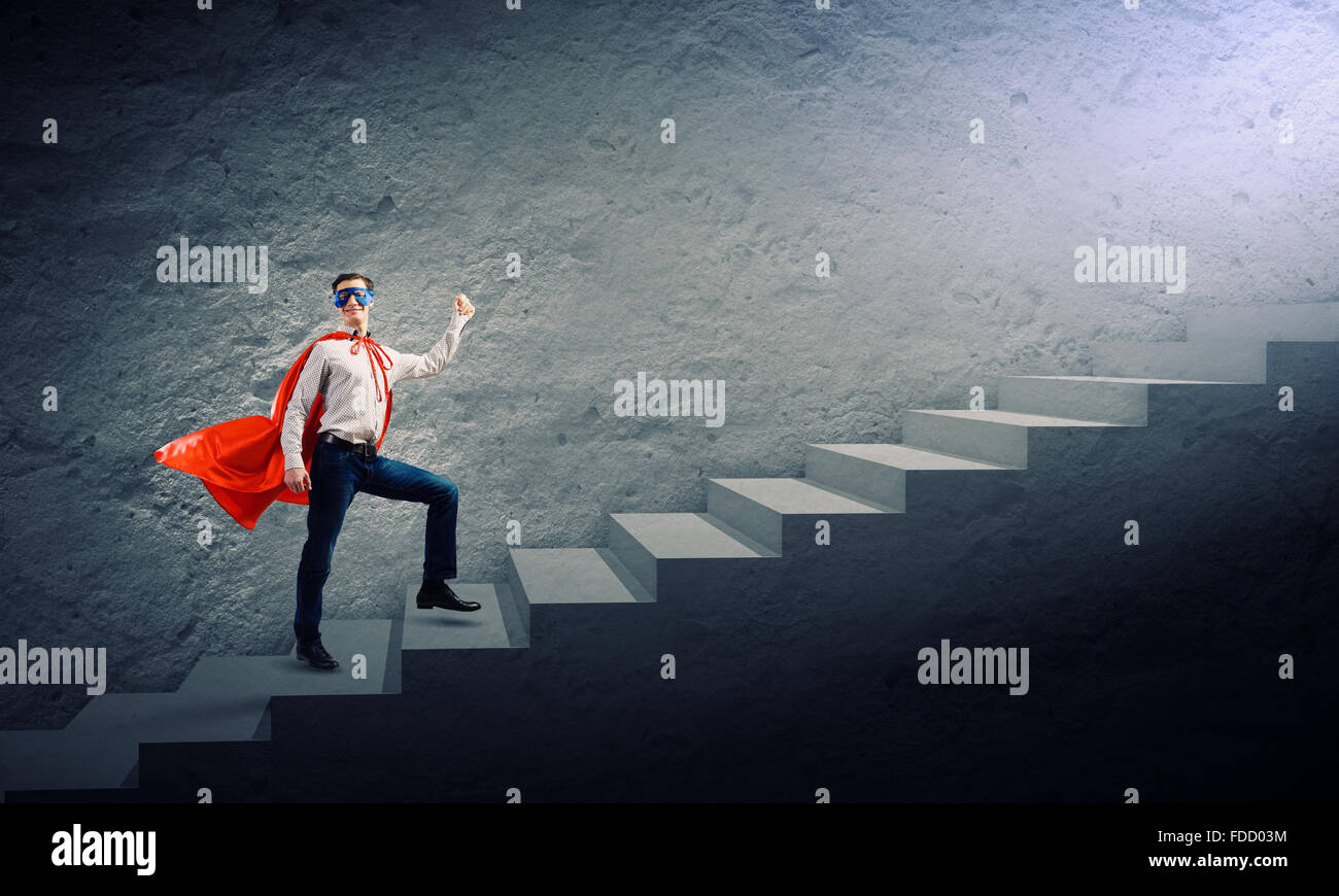 Young superman walking up the stair case Stock Photo - Alamy