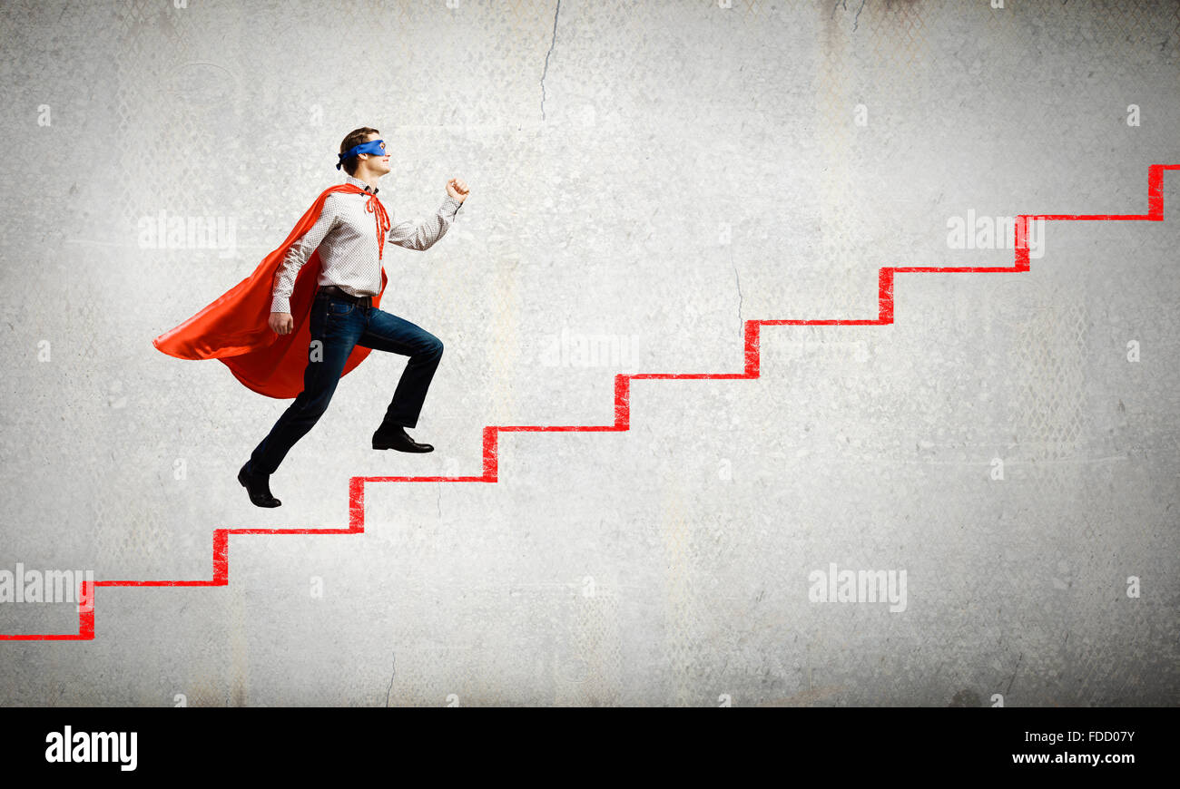 Young superman walking up the stair case Stock Photo - Alamy