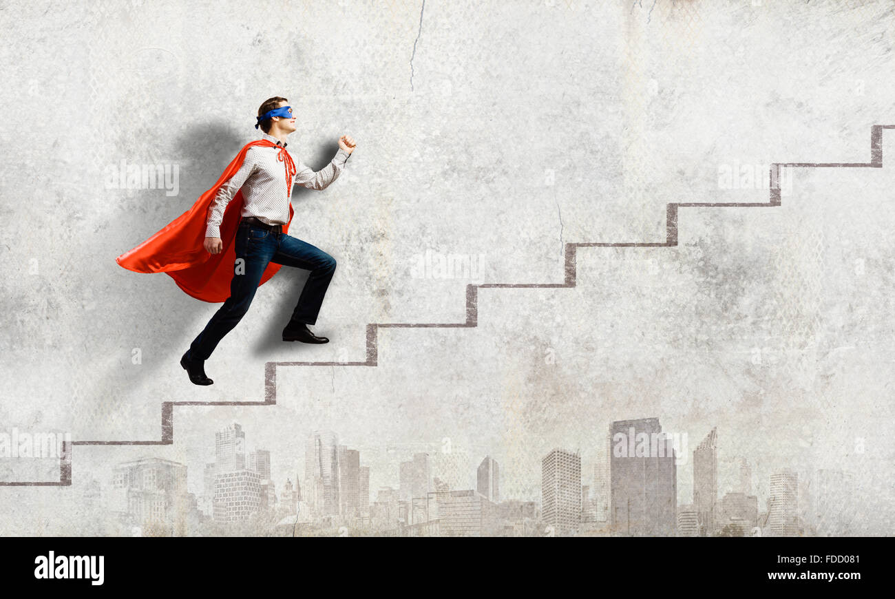 Young superman walking up the stair case Stock Photo - Alamy