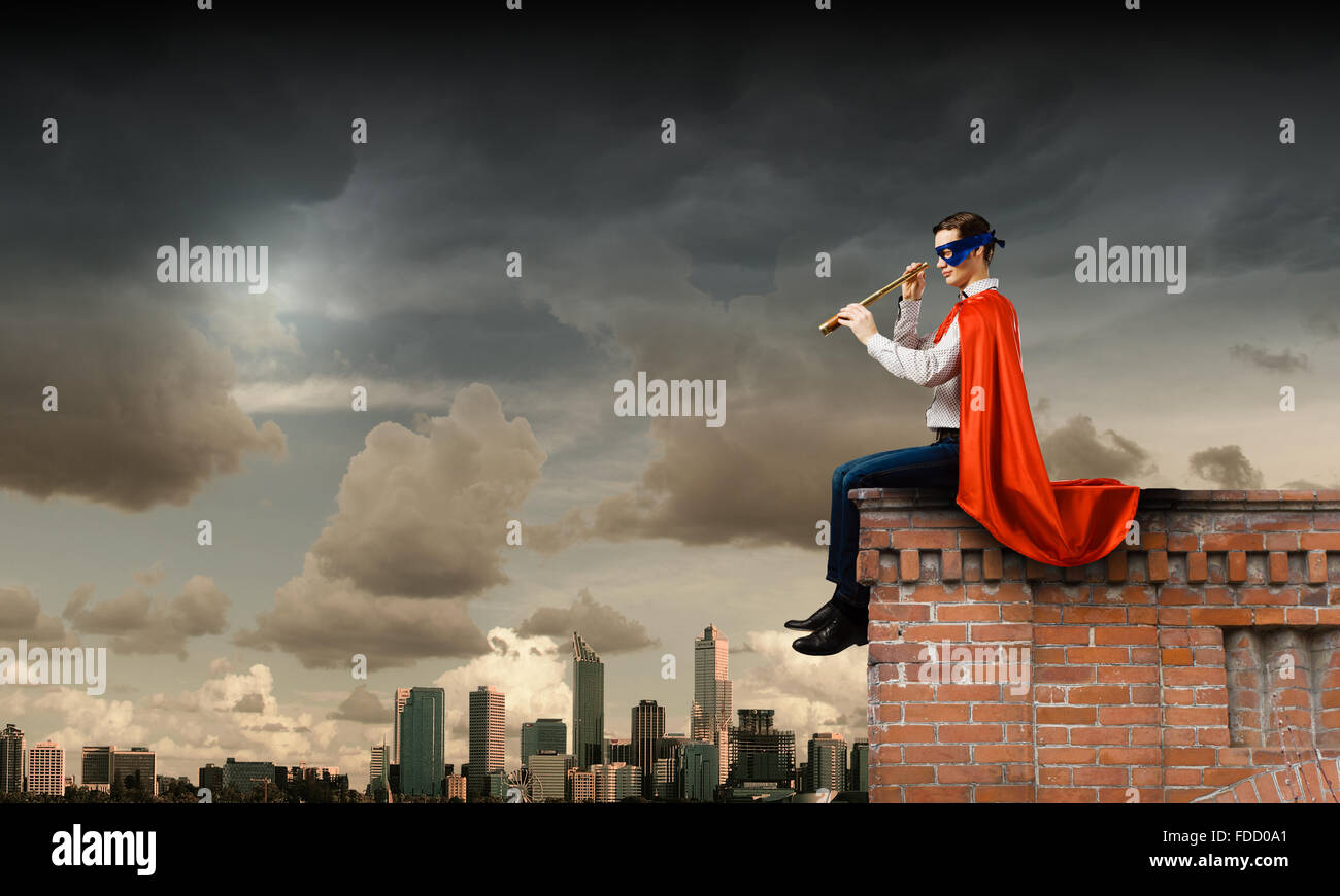 Young man in superhero costume on top of building Stock Photo - Alamy