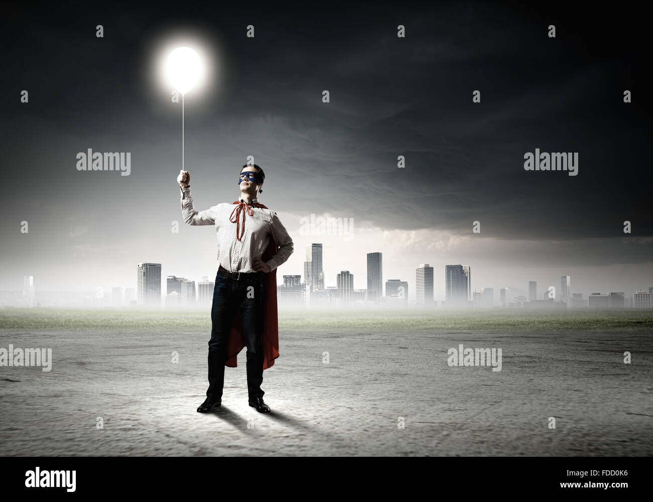 Young man in superhero costume holding balloon in hand Stock Photo - Alamy