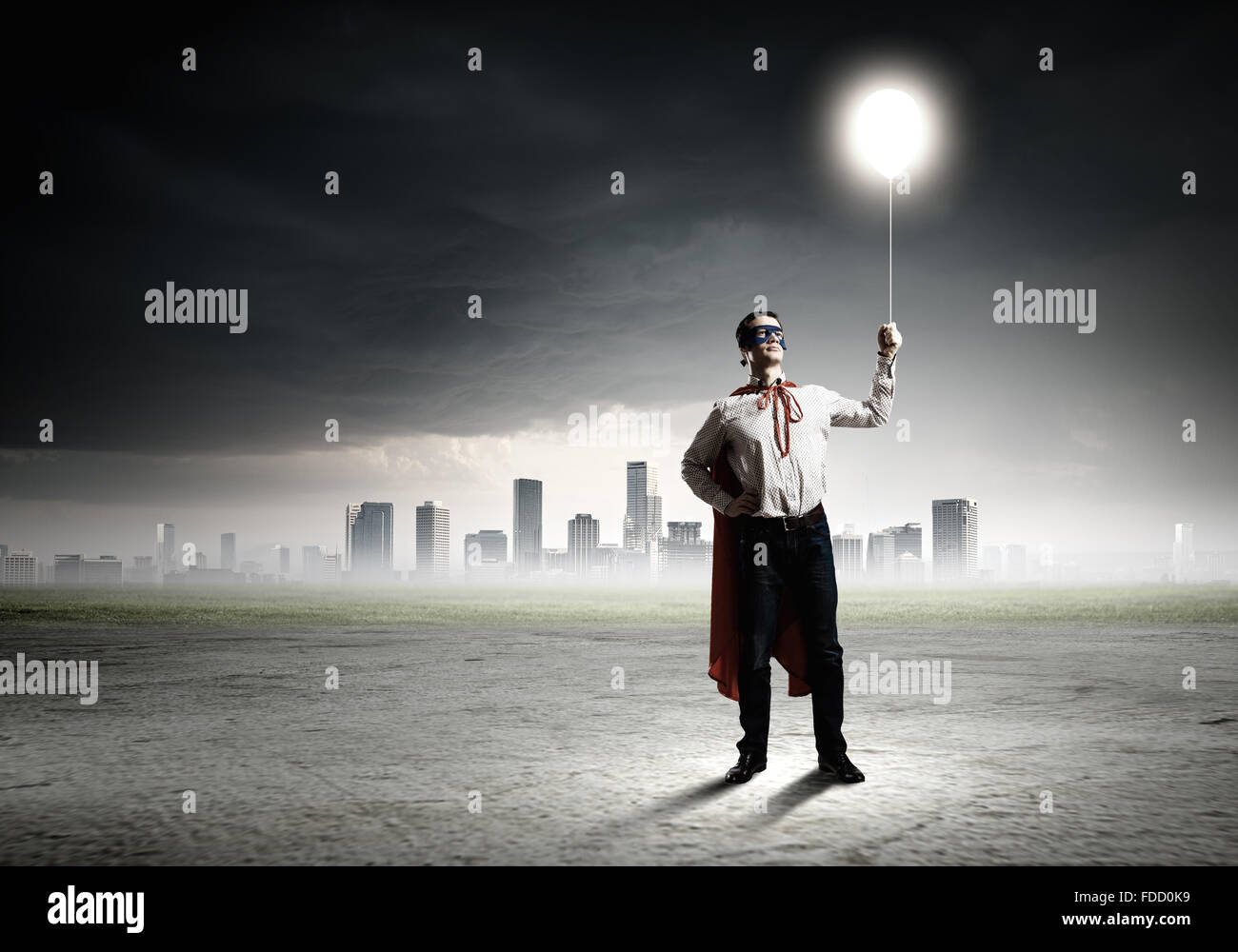 Young man in superhero costume holding balloon in hand Stock Photo - Alamy
