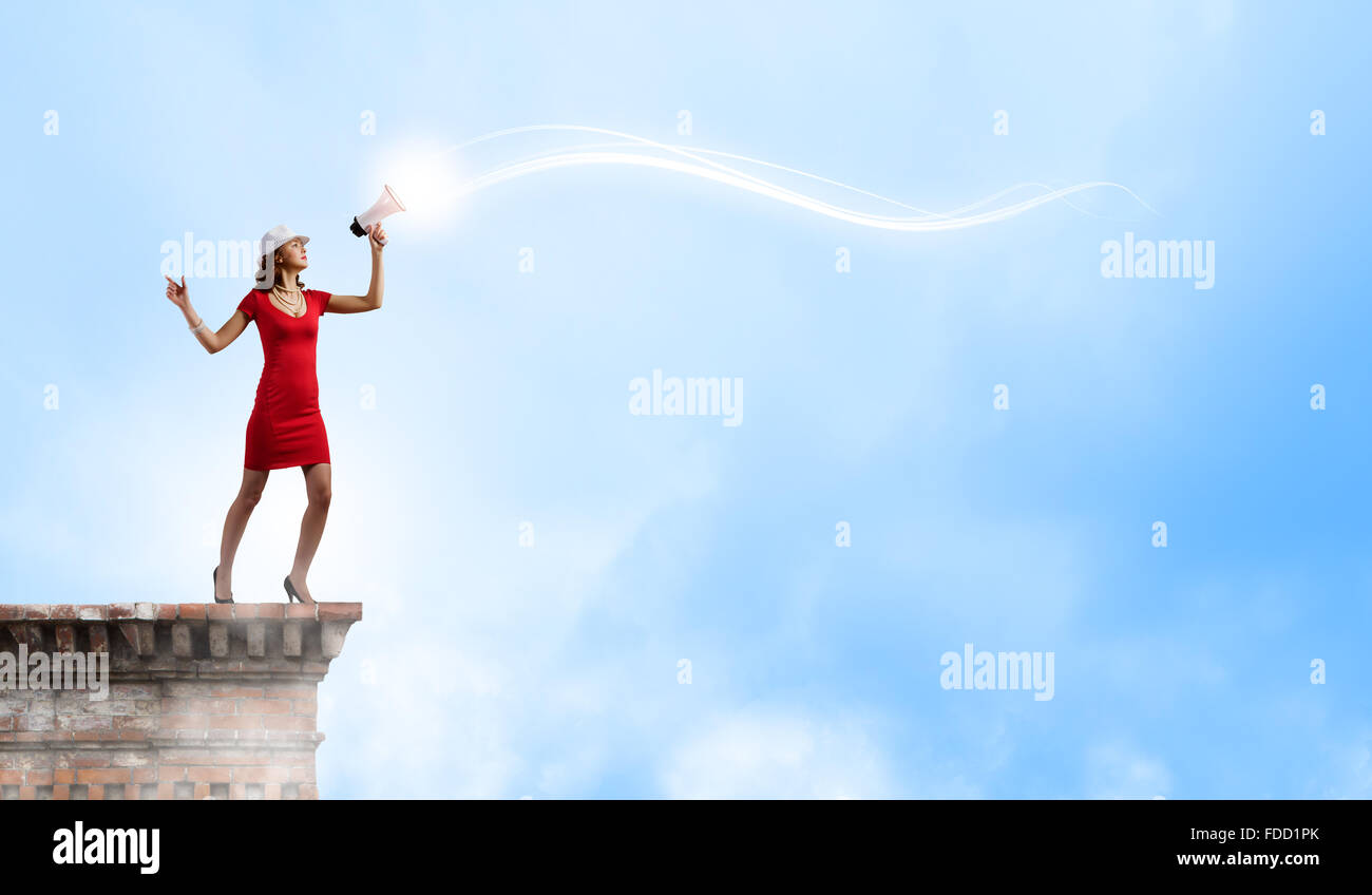 Pretty woman in red dress screaming in megaphone Stock Photo - Alamy