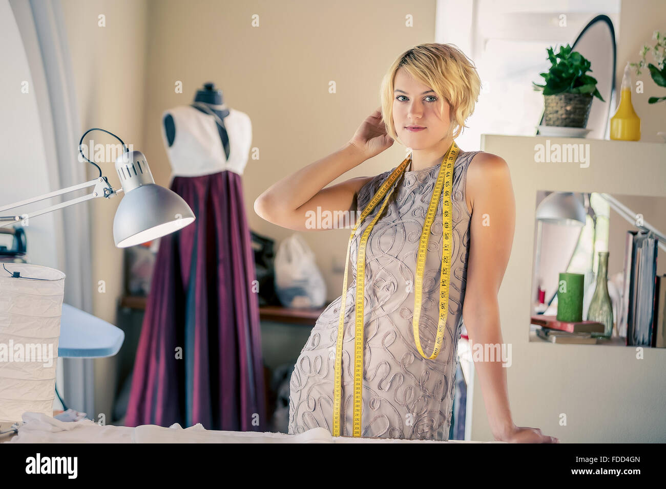 Young woman dressmaker at tailors making measures Stock Photo - Alamy