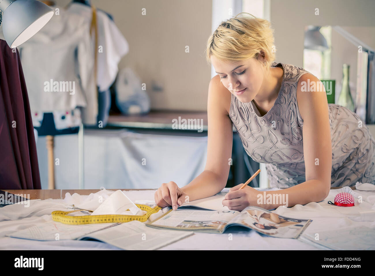 Young woman dressmaker at tailors making measures Stock Photo - Alamy