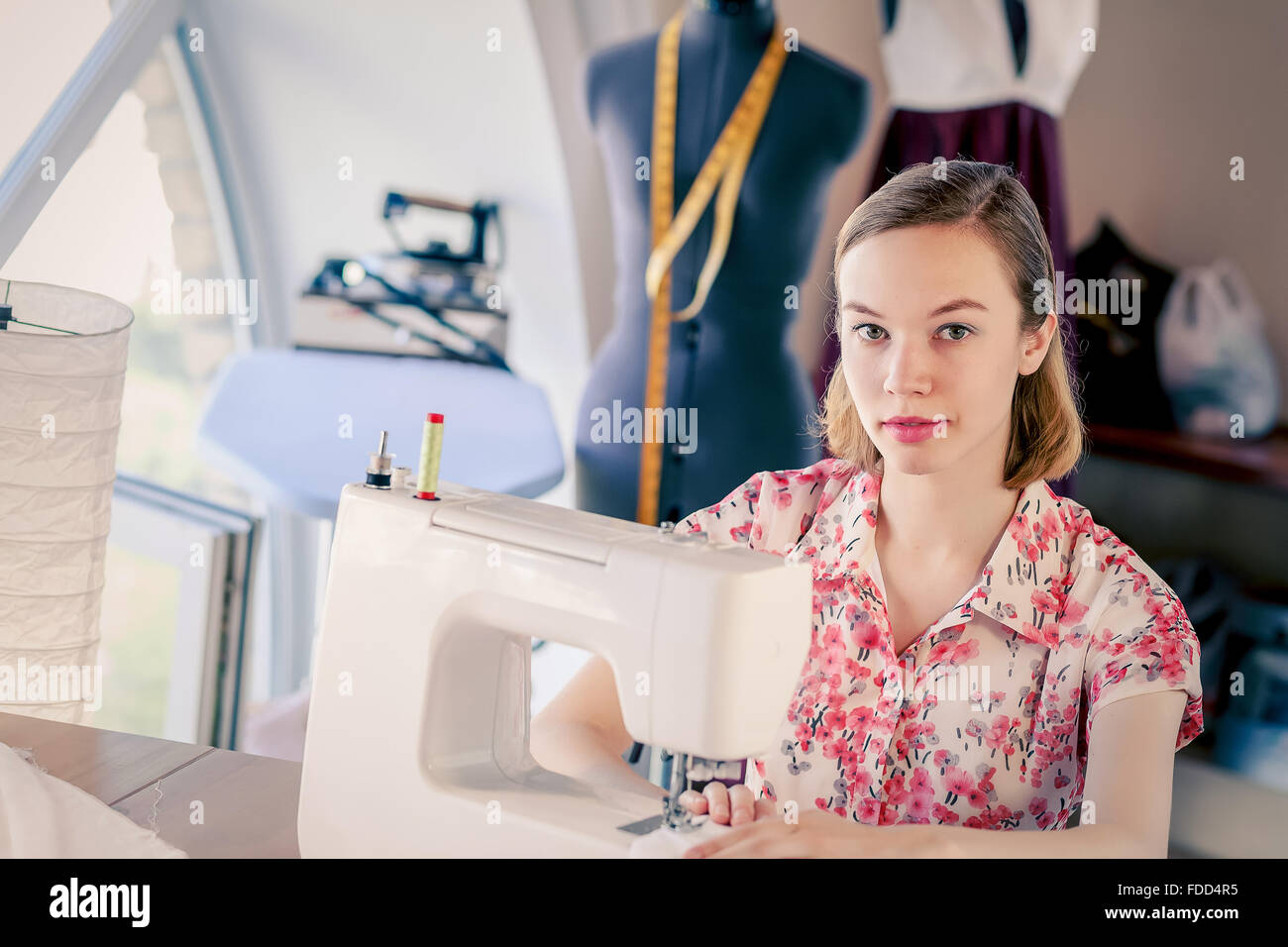 Young woman dressmaker working on sewing machine Stock Photo - Alamy