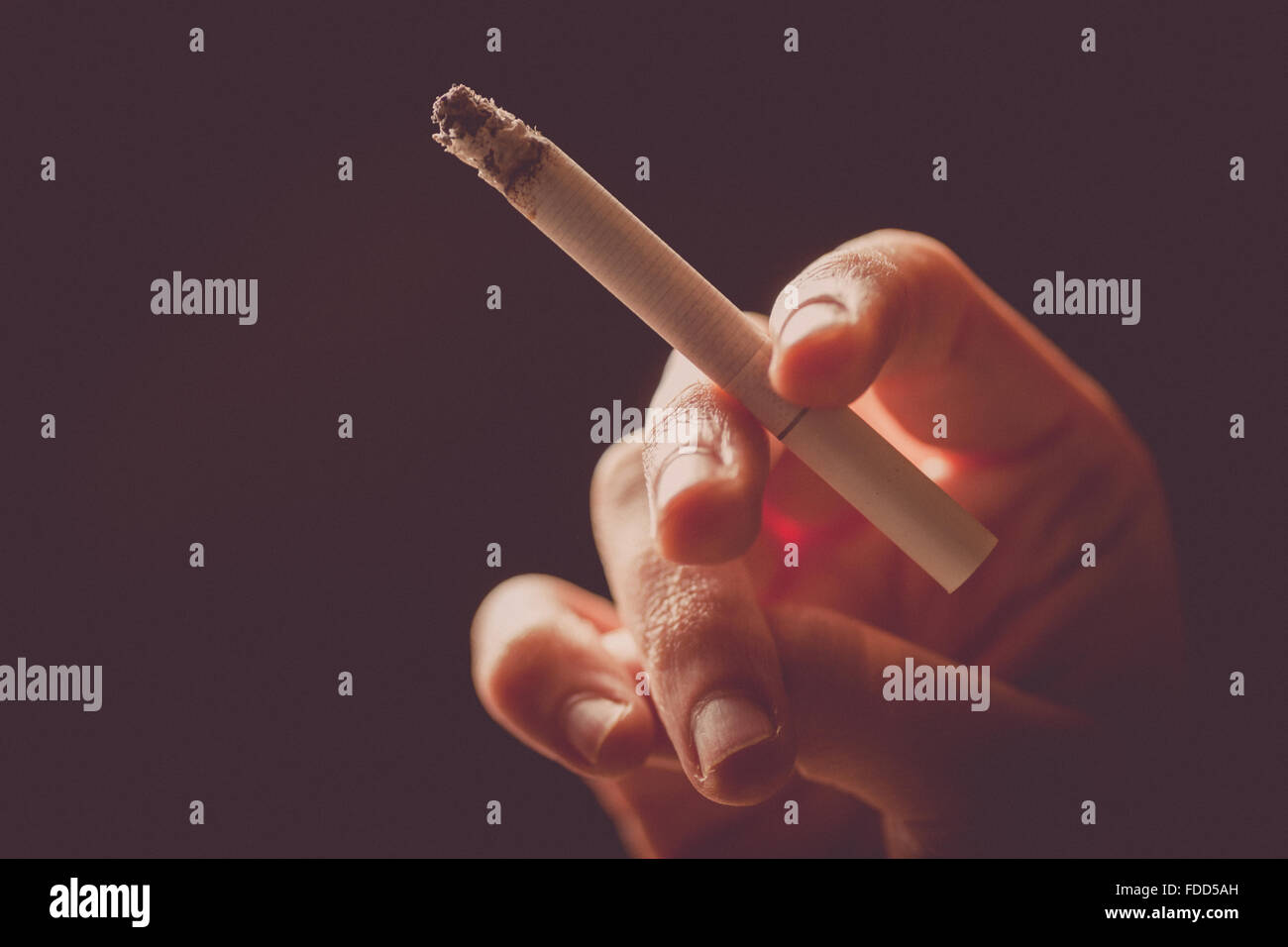 Color image of a hand holding a cigarette Stock Photo - Alamy