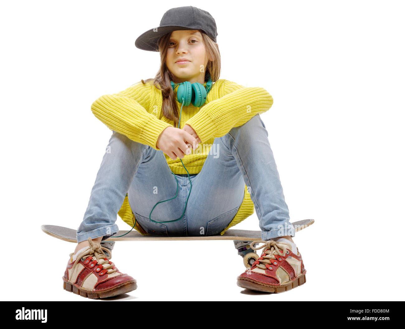 a pretty young girl posing with a skateboard, sitting on skate, on ...