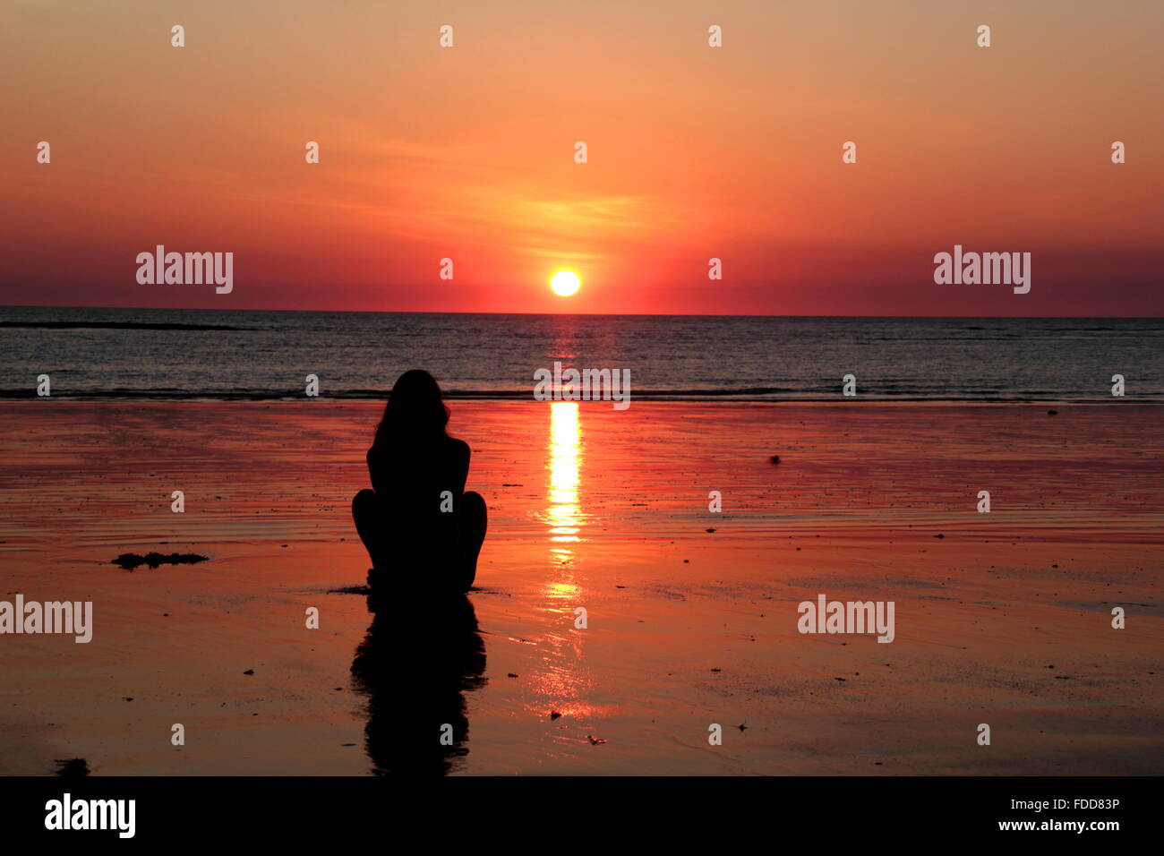 woman is watching the sunset at the beach Stock Photo - Alamy