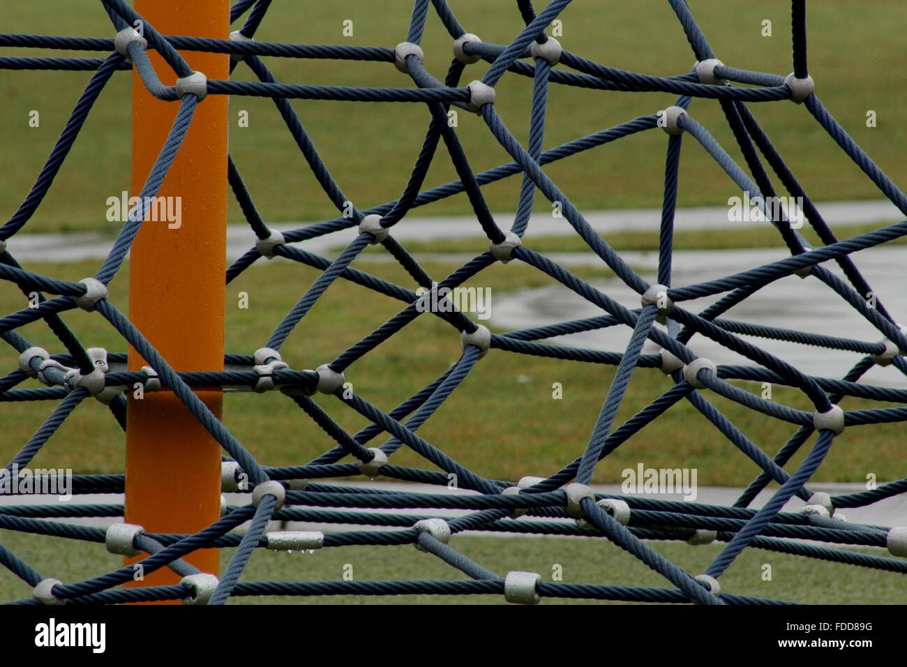 Playground equipment webbing around an orange pole Stock Photo - Alamy