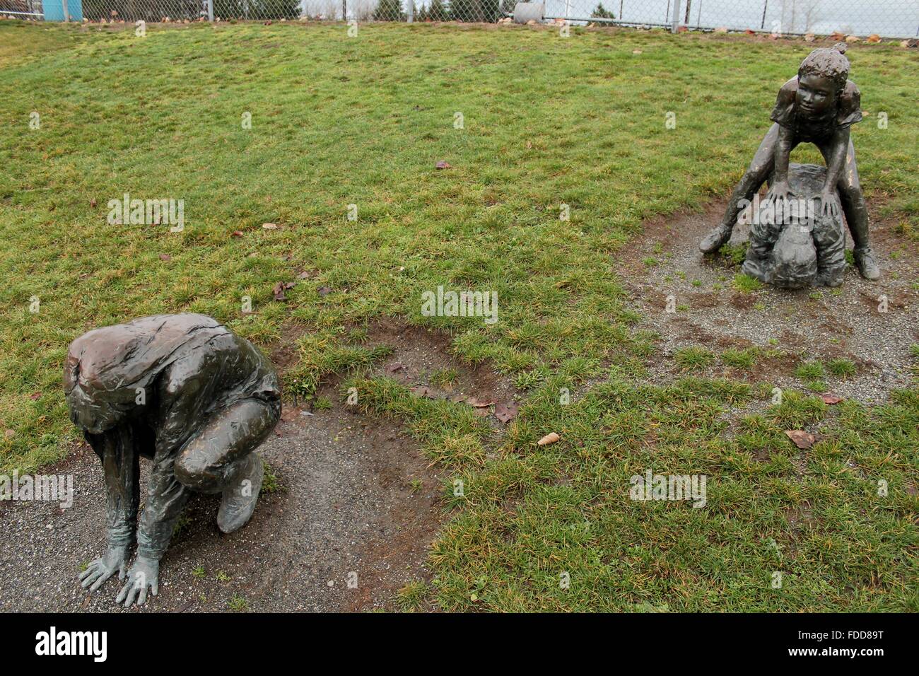 Pair of bronze statues of children playing in a park Stock Photo - Alamy