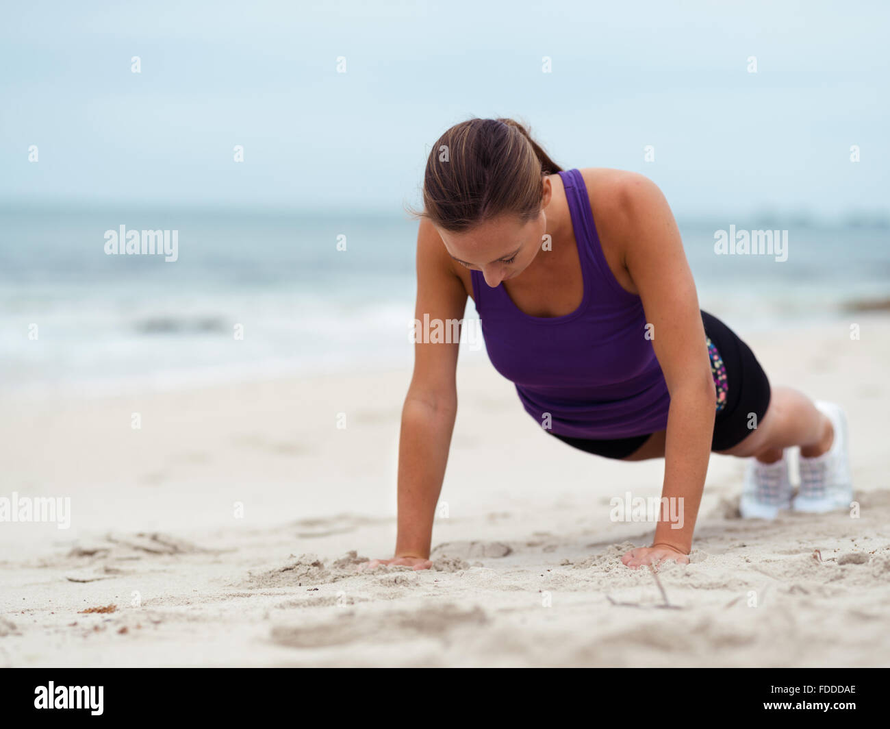 Sporty young woman doing push ups on the sea coast Stock Photo - Alamy