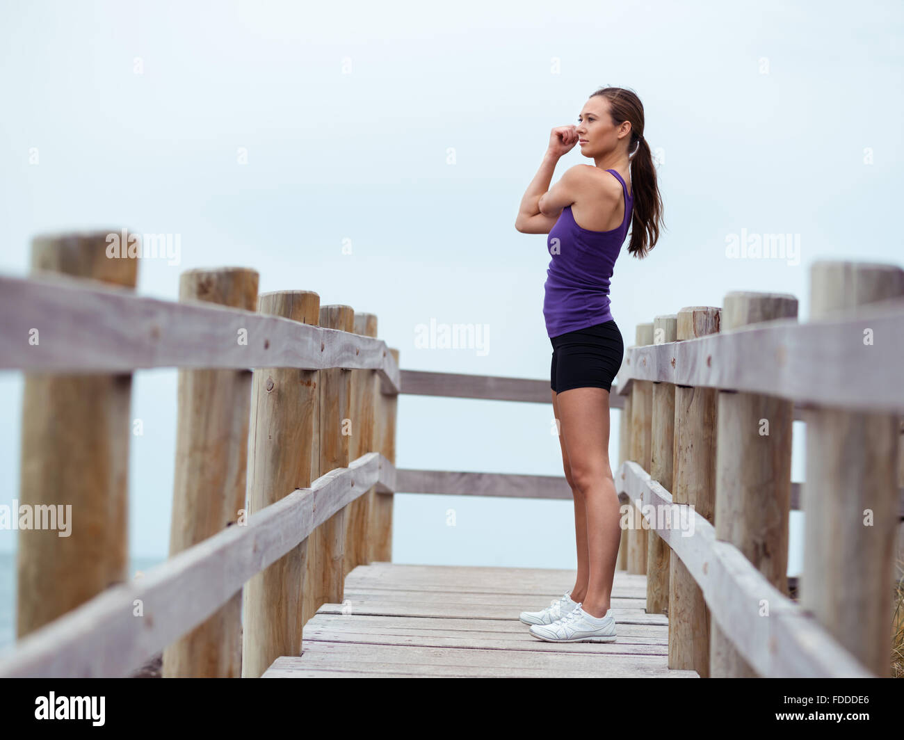 Sporty young woman stretching on the sea coast Stock Photo - Alamy
