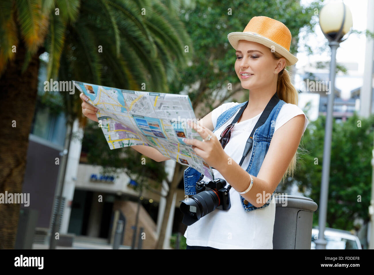 Happy young woman with a map Stock Photo - Alamy