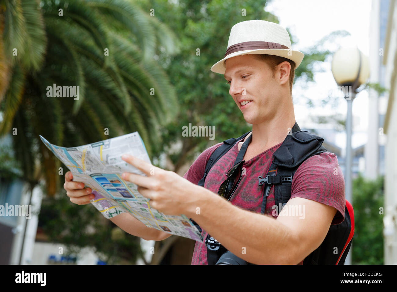 Happy young man with a map Stock Photo - Alamy