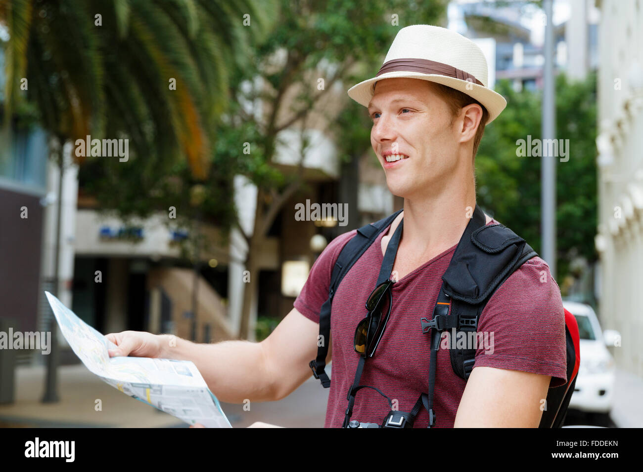 Happy young man with a map Stock Photo - Alamy