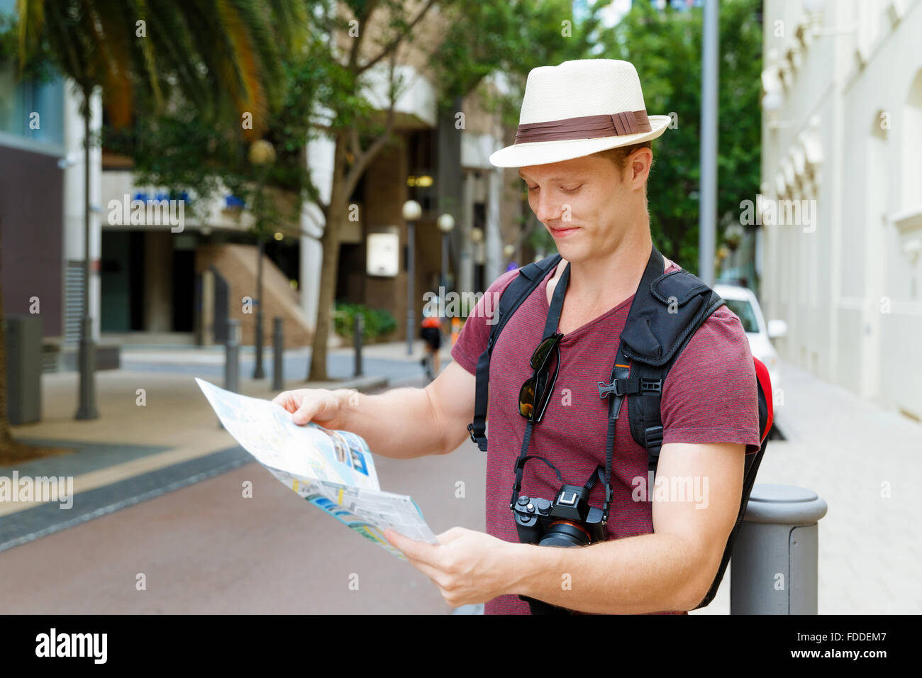 Happy young man with a map Stock Photo - Alamy