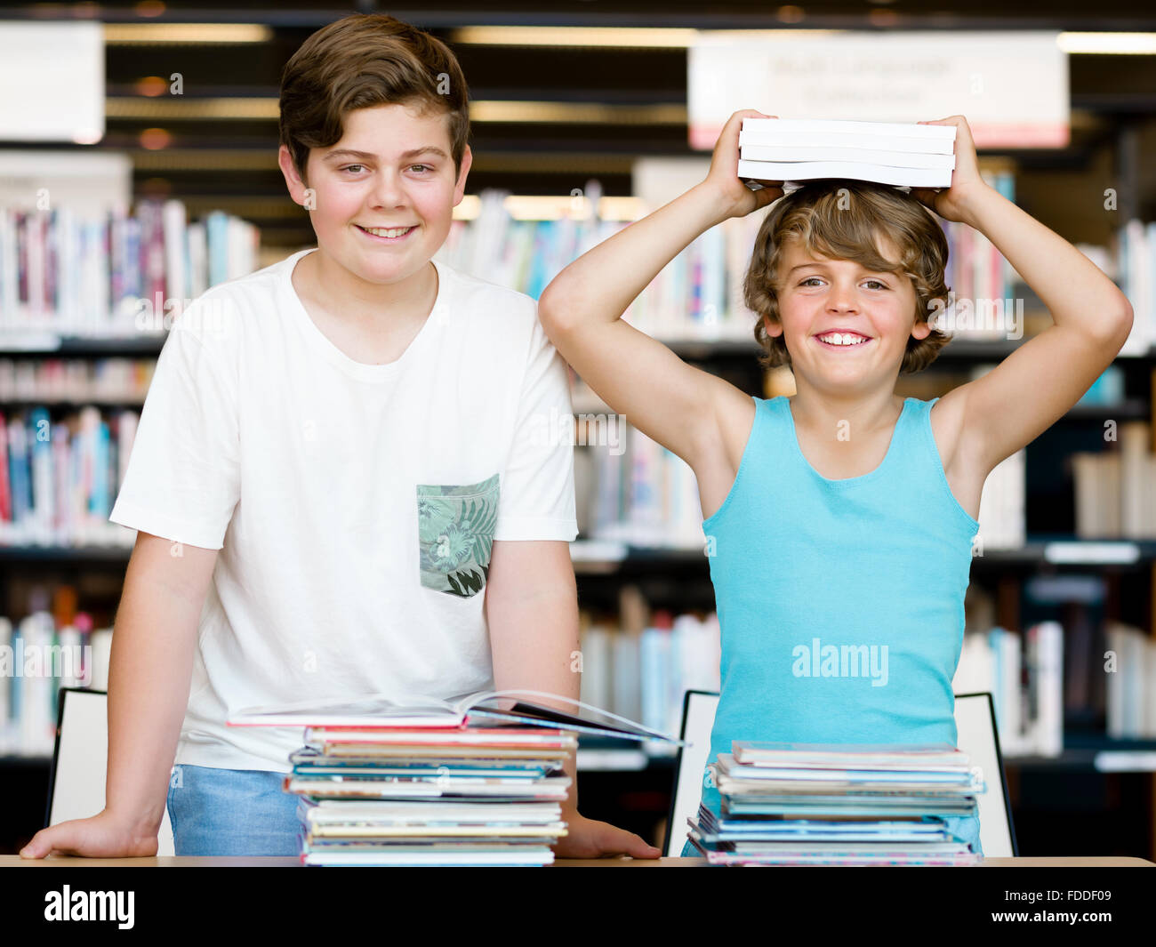 Two boys in library with books Stock Photo - Alamy