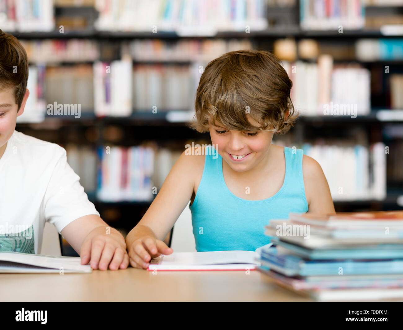 Boy in library with books Stock Photo - Alamy