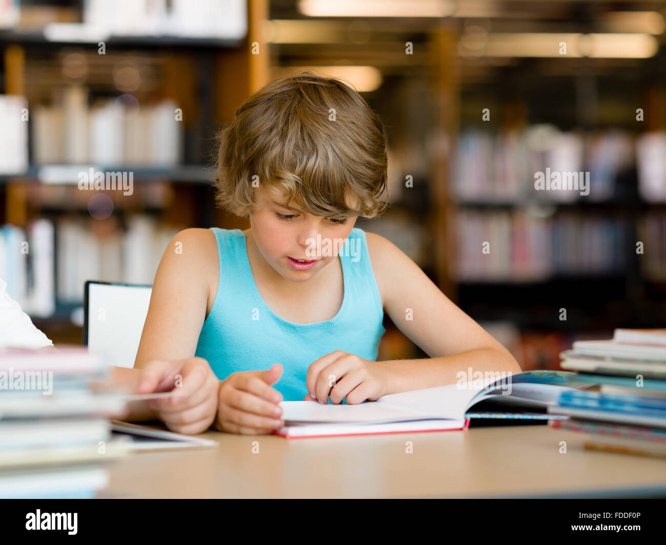 Boy in library with books Stock Photo - Alamy