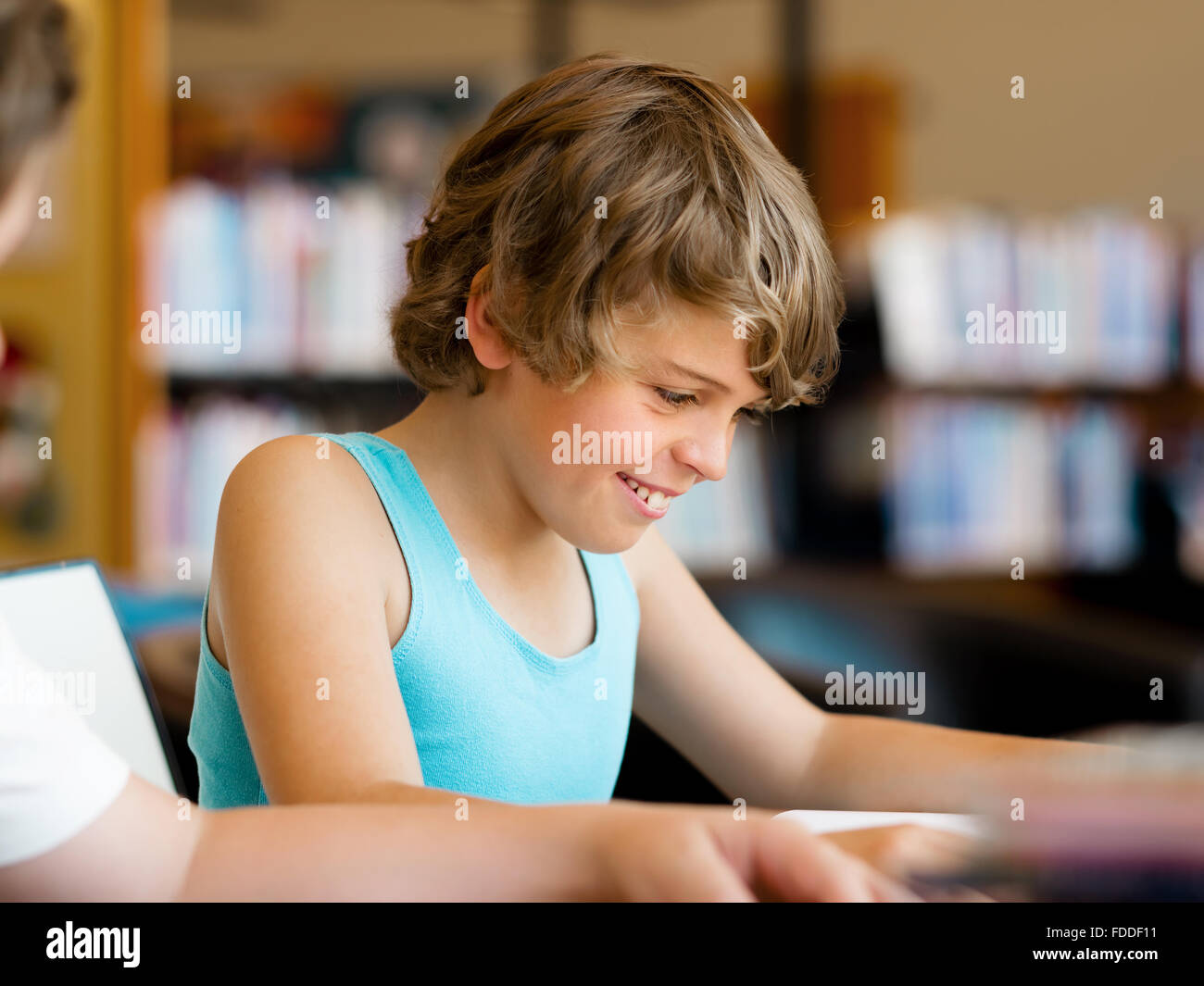 Boy in library with books Stock Photo - Alamy