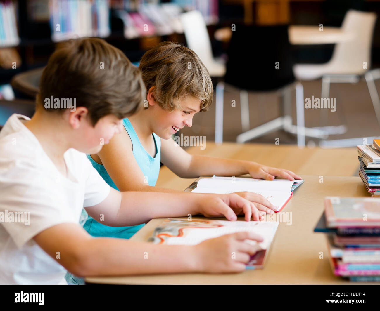 Two boys in library with books Stock Photo - Alamy
