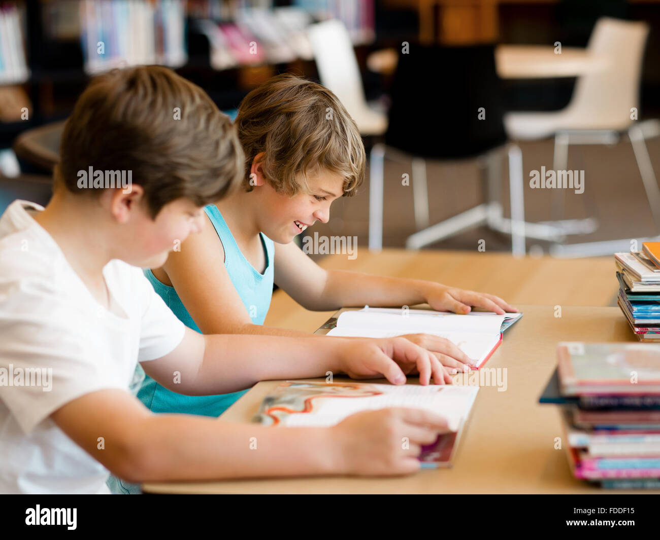 Two boys in library with books Stock Photo - Alamy
