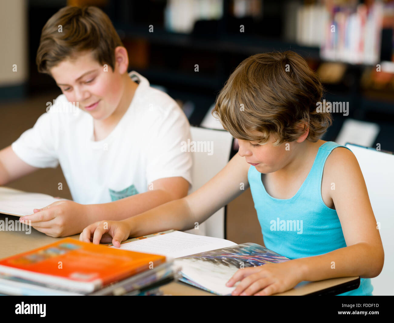 Two boys in library with books Stock Photo - Alamy
