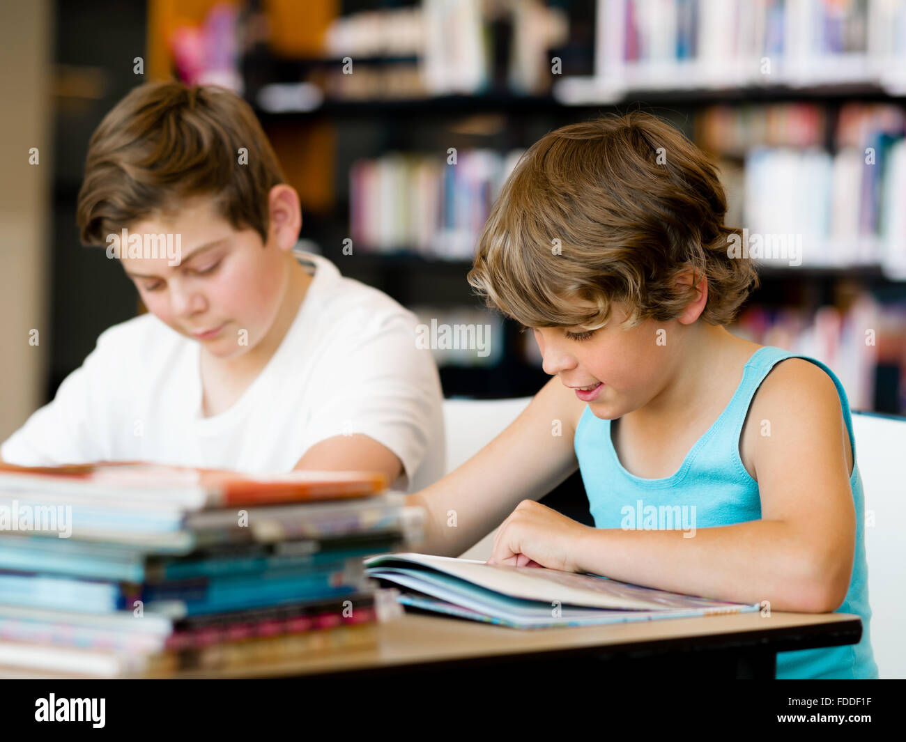 Two boys in library with books Stock Photo - Alamy