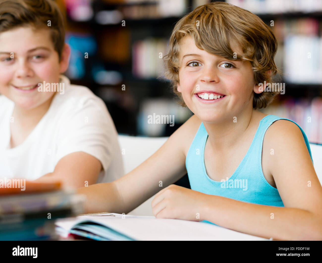 Two boys in library with books Stock Photo - Alamy