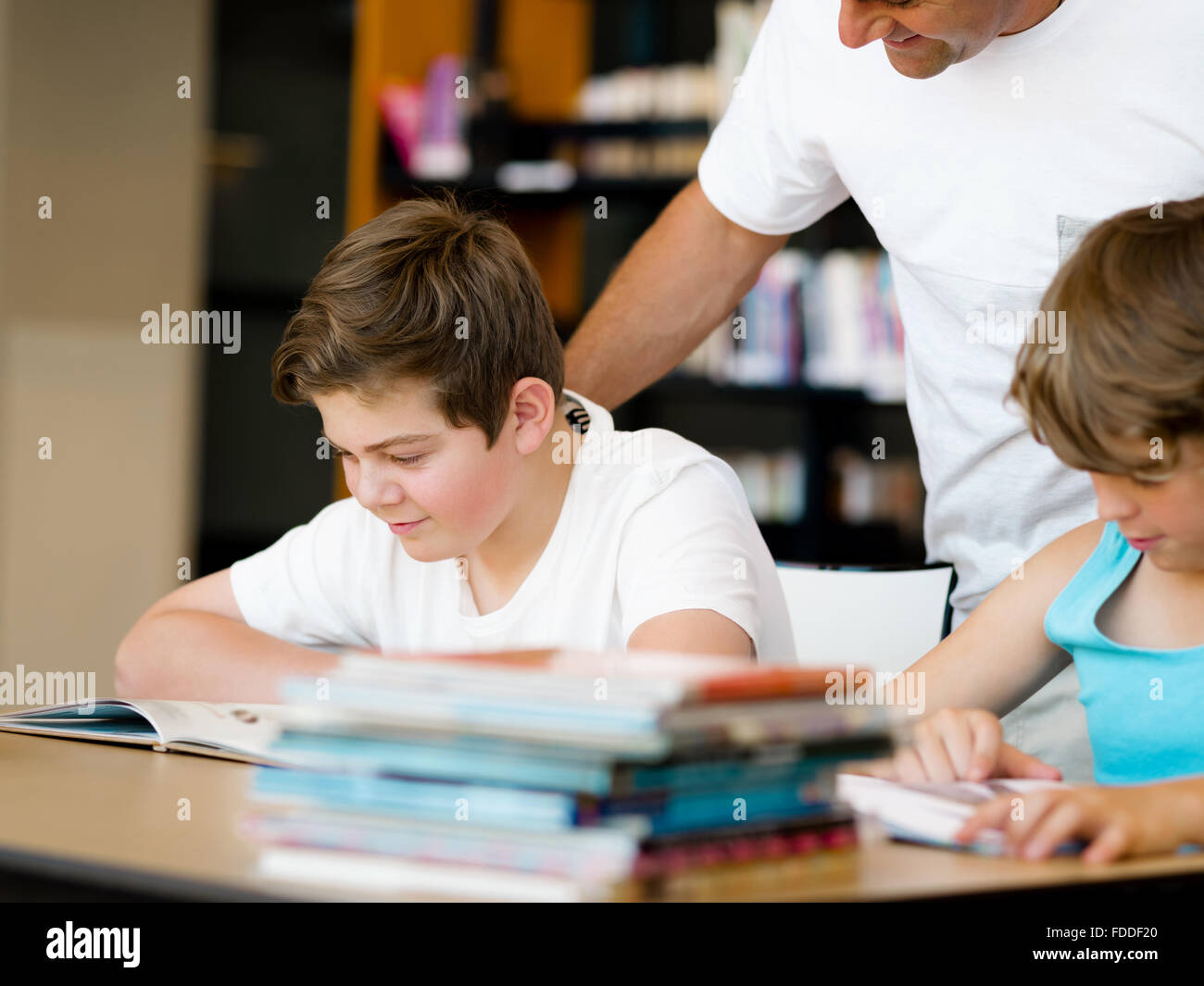Two boys in library with books Stock Photo - Alamy