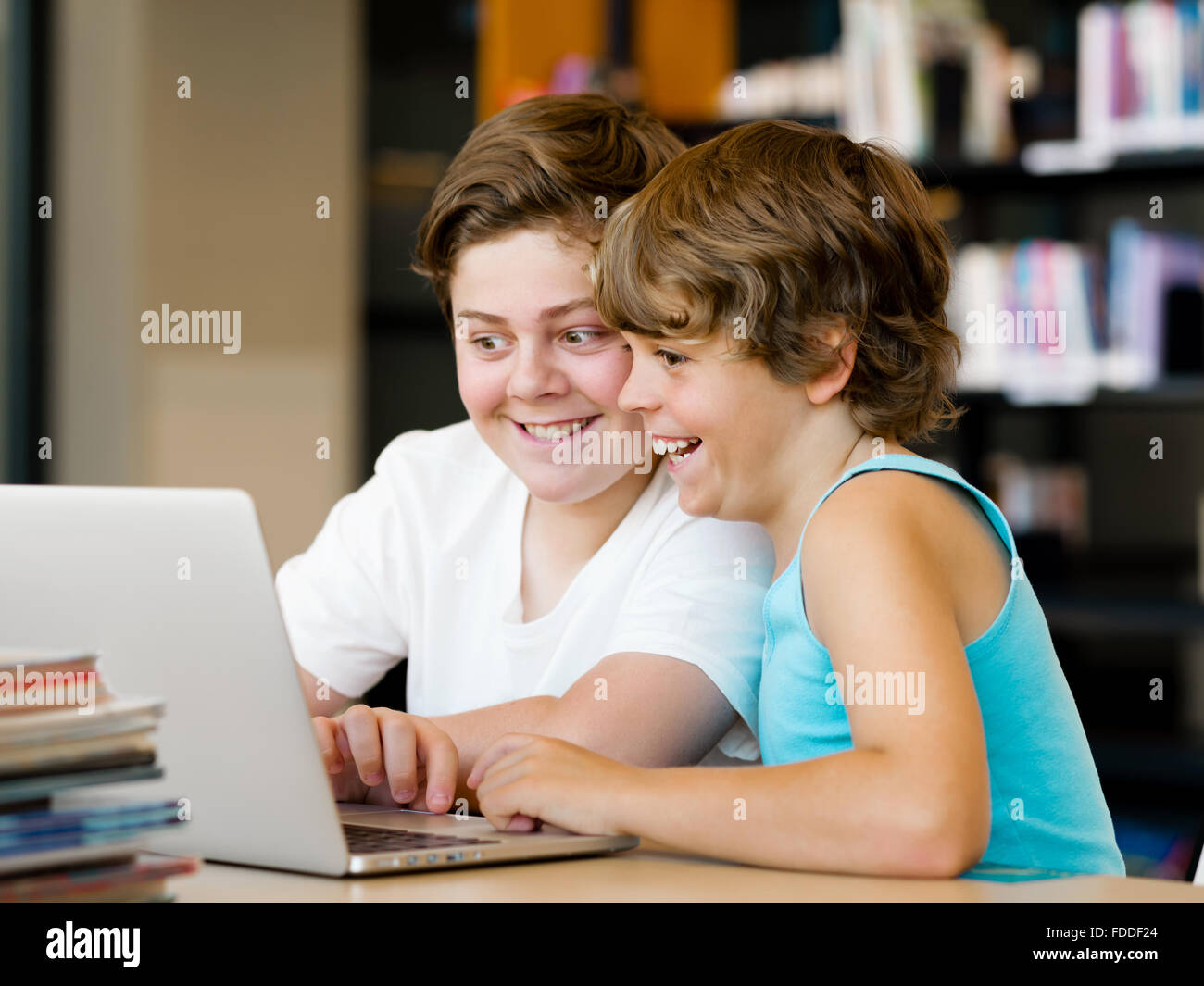 Two boys in library with notebook Stock Photo - Alamy