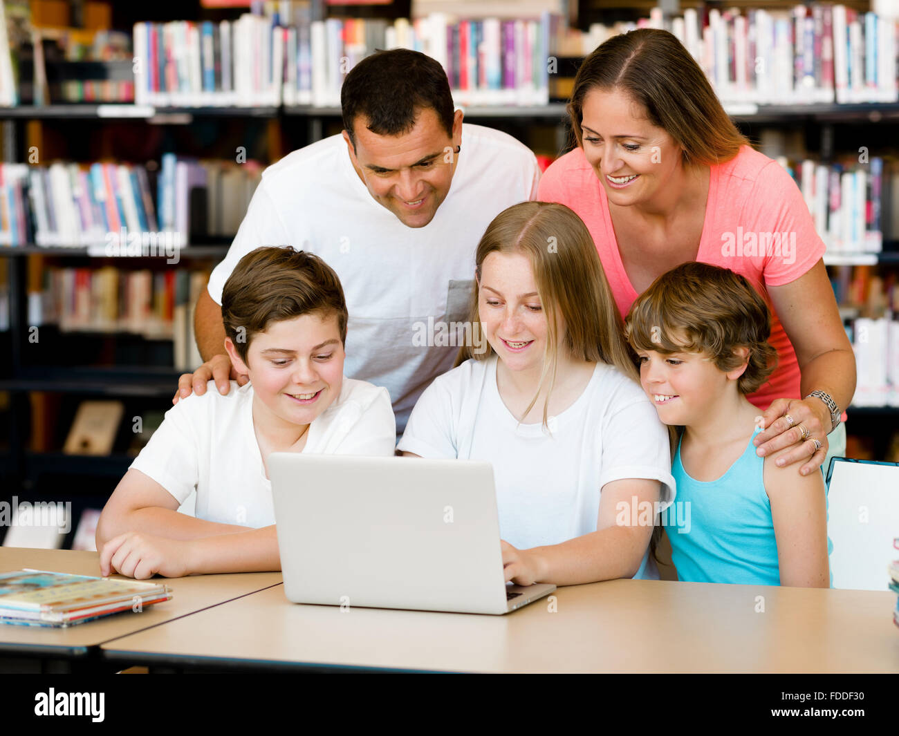 Family in library with books Stock Photo - Alamy