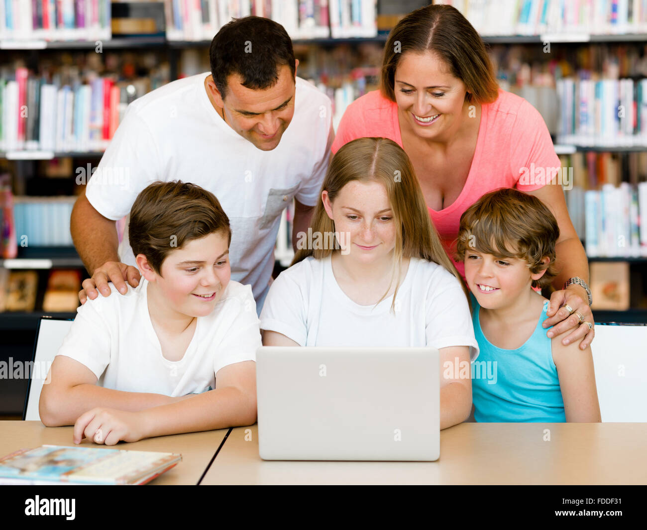 Family in library with books Stock Photo - Alamy