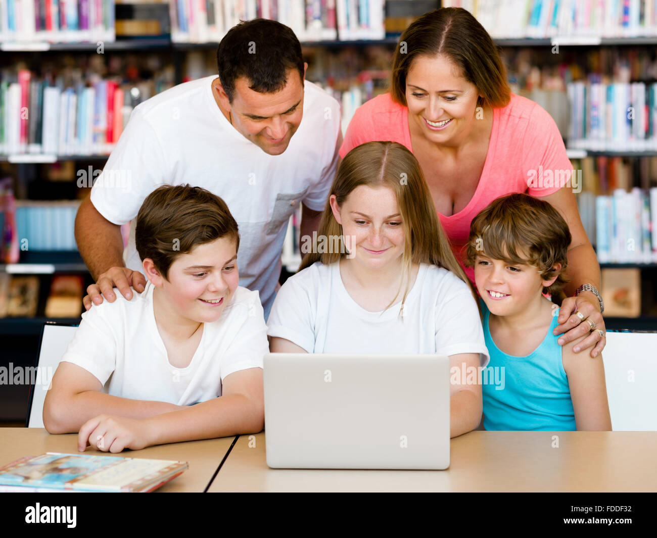 Family in library with books Stock Photo - Alamy