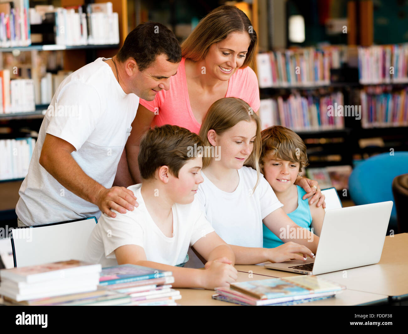 Family in library with books Stock Photo - Alamy