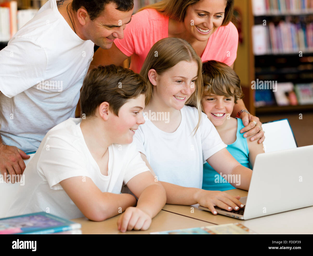 Family in library with books Stock Photo - Alamy